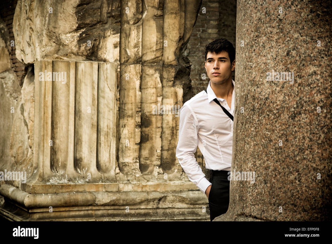 Handsome young man between ancient marble columns Stock Photo - Alamy