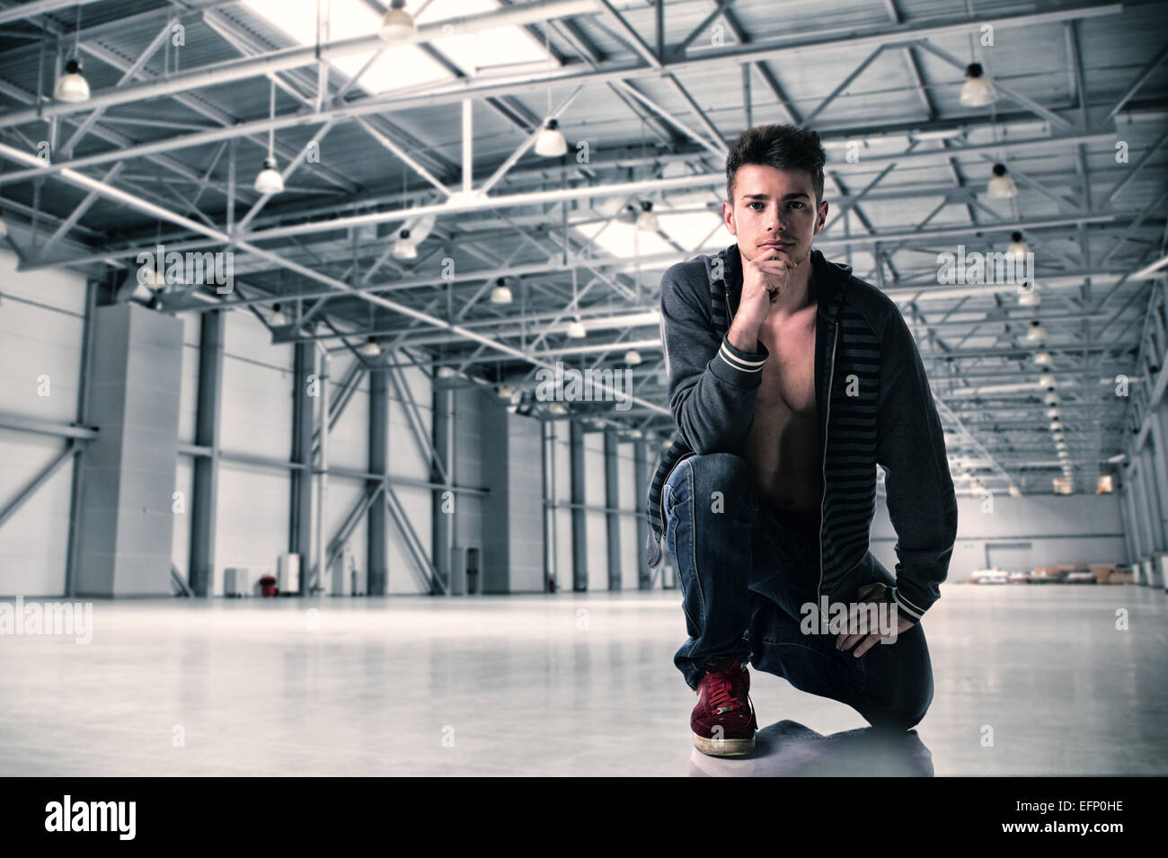 Handsome young man in empty warehouse Stock Photo - Alamy