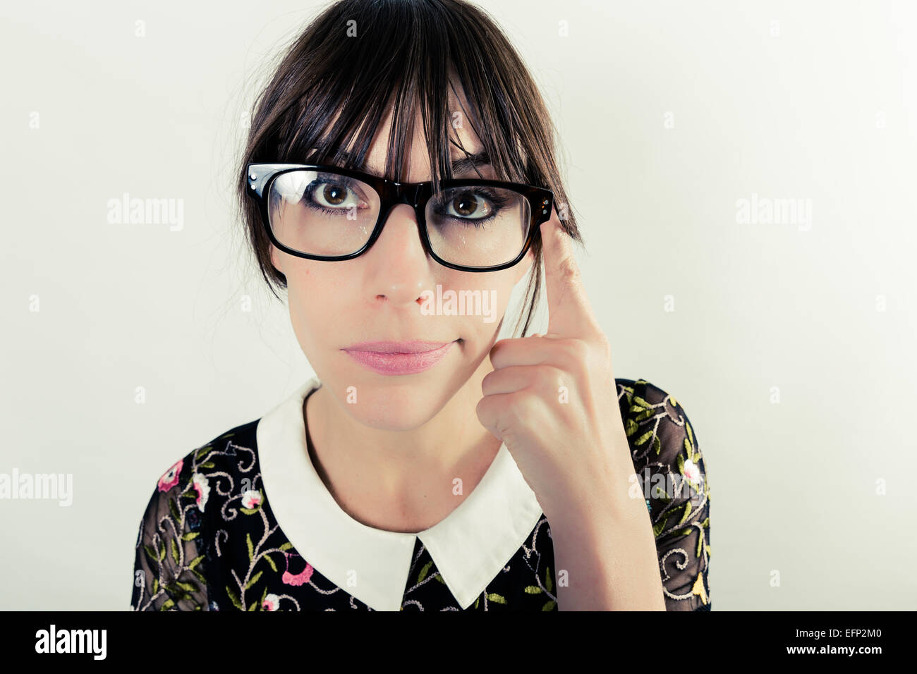 Girl wearing glasses in thinking pose Stock Photo - Alamy
