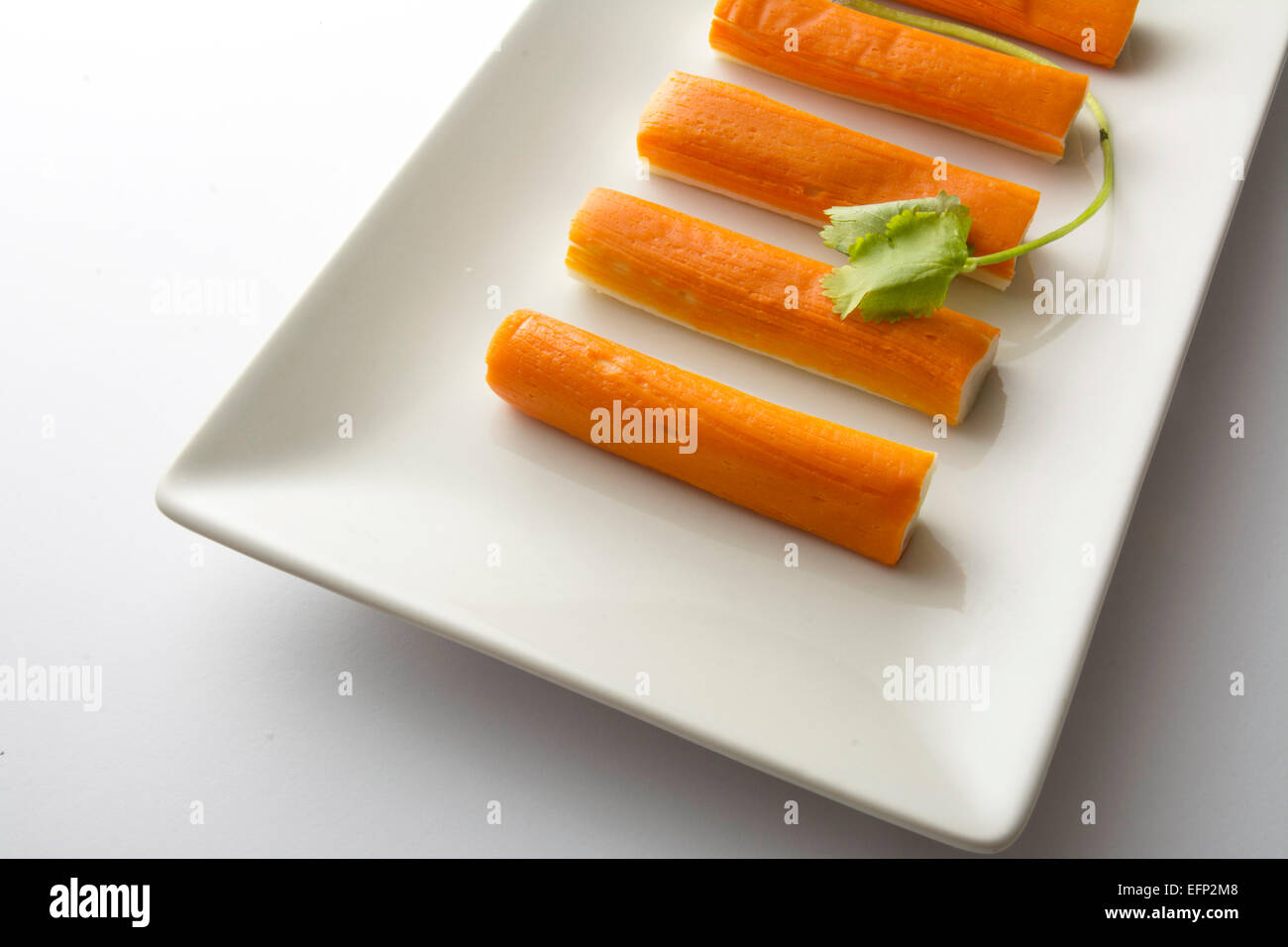 Surimi or crab sticks in a white rectangular plate. . White background ...
