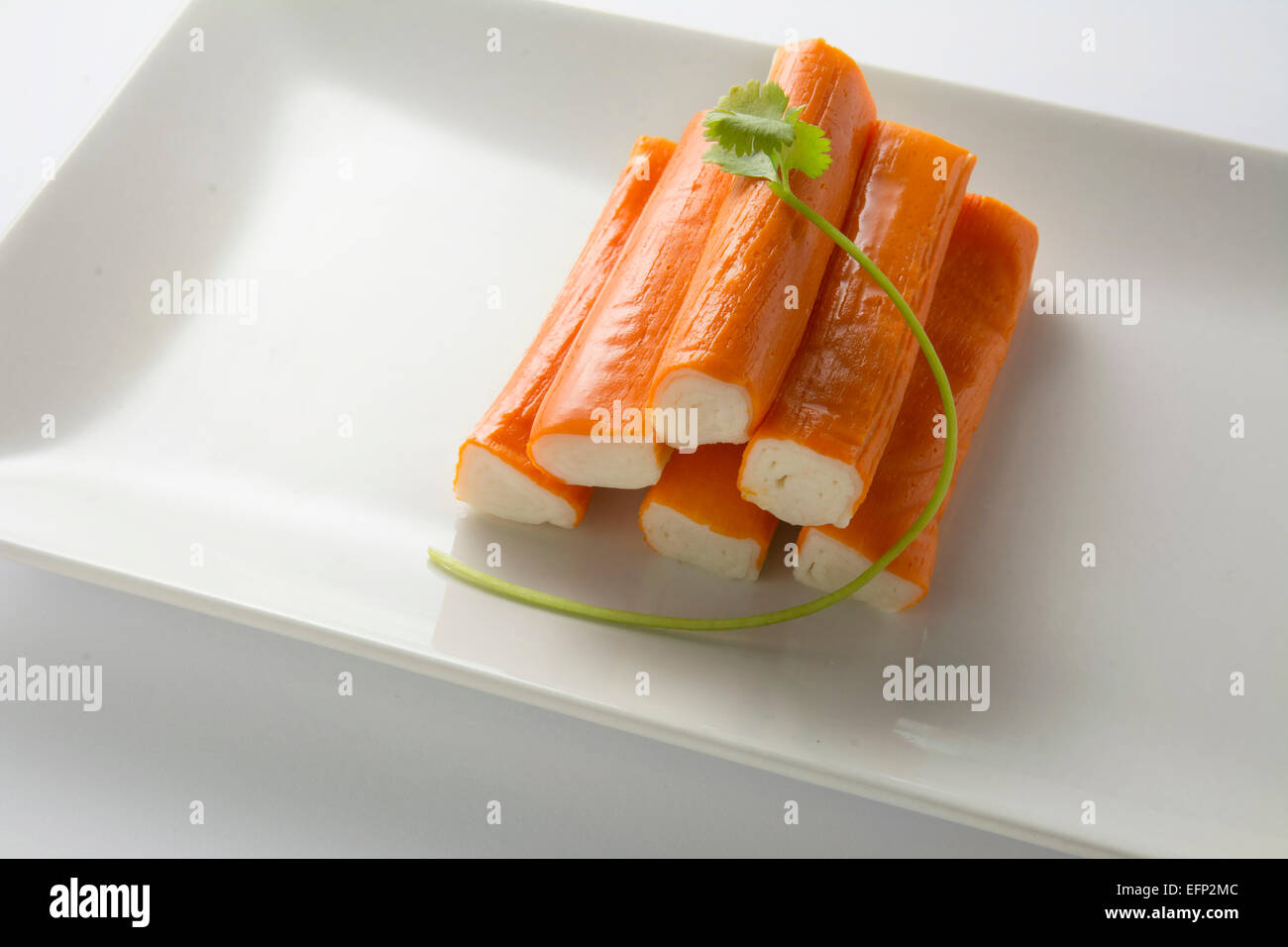 Surimi or crab sticks in a white rectangular plate. . White background ...