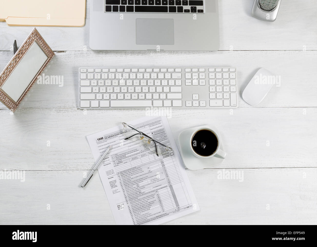 Top view angle of office desktop consisting of laptop, keyboard, pens ...