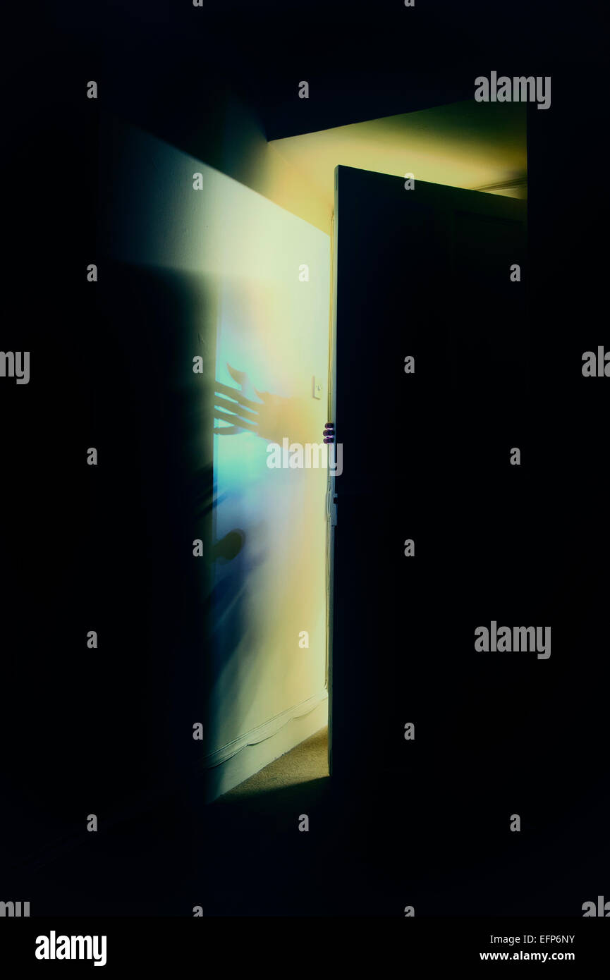 Shadow of a man opening a door into a dark room at night Stock Photo ...