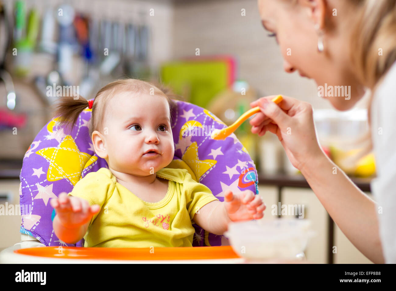 Mother spoon feeding child toddler Stock Photo - Alamy