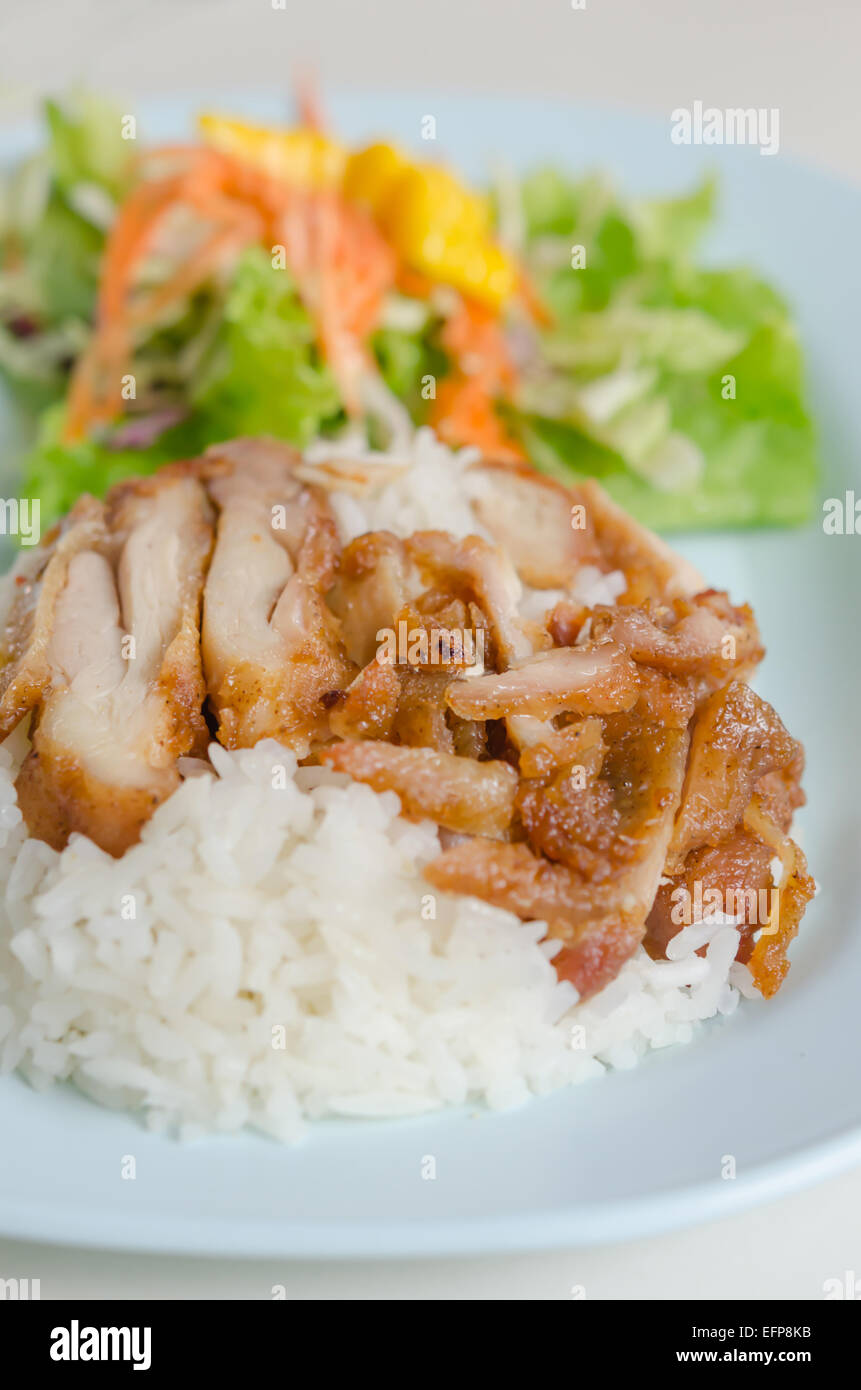 close up fried chicken over steamed rice on plate , served with salad ...