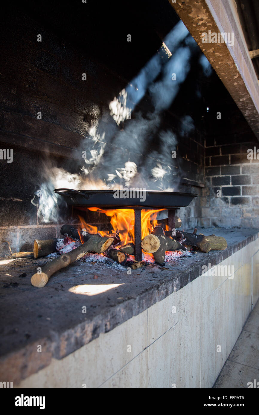 Spanish typical Paella on fire and sun ray light Stock Photo - Alamy