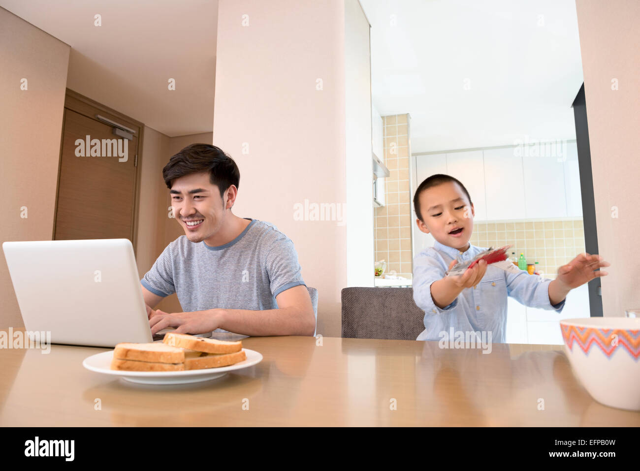 Father working at home with son Stock Photo - Alamy