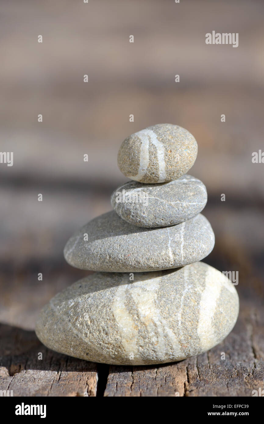 Stack of pebble stones on wood Stock Photo - Alamy