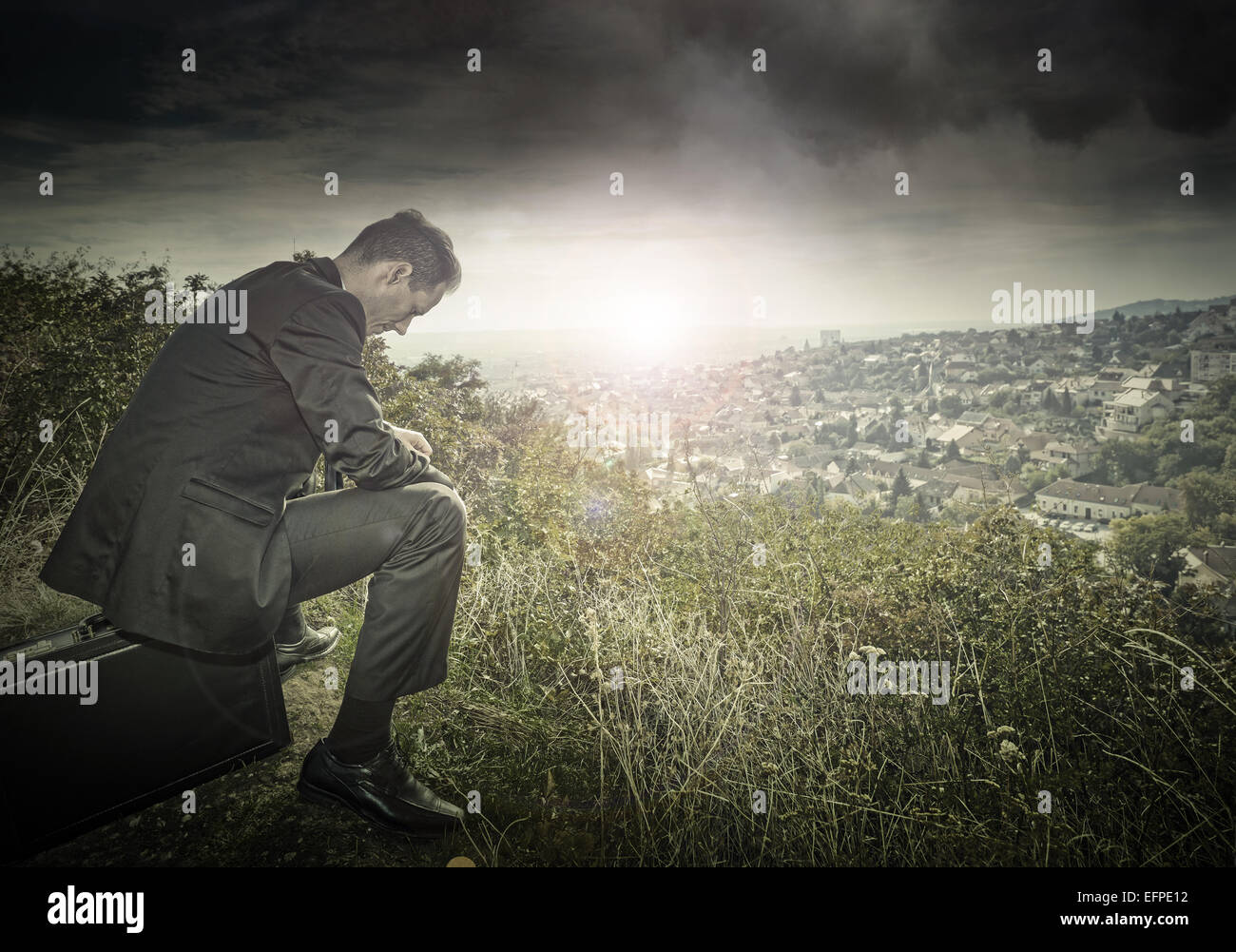 Sad, lonely businessman on the hillside Stock Photo - Alamy