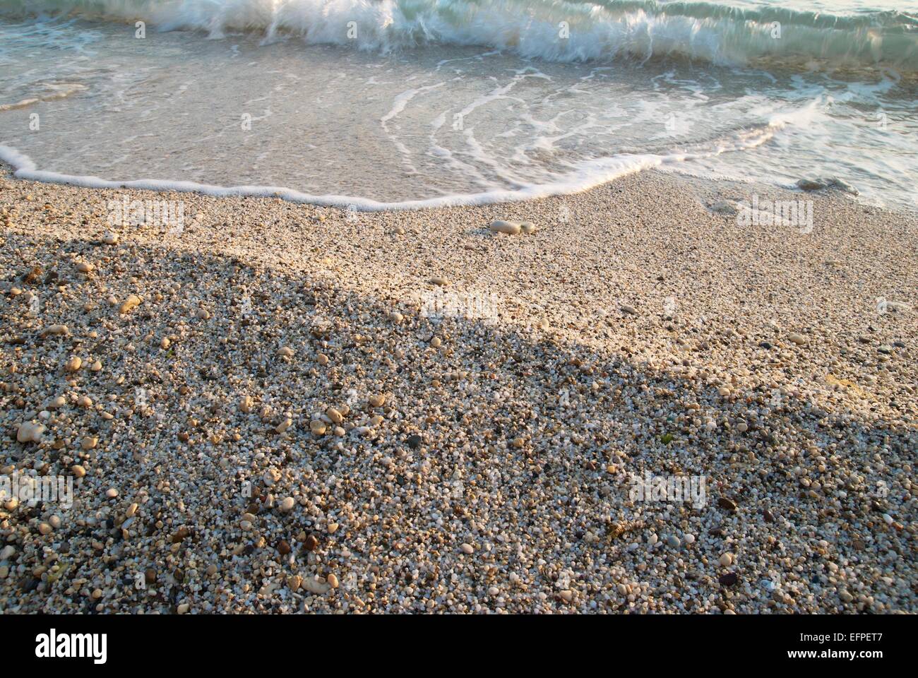Tropical sand beach with sea waves and stones Stock Photo - Alamy