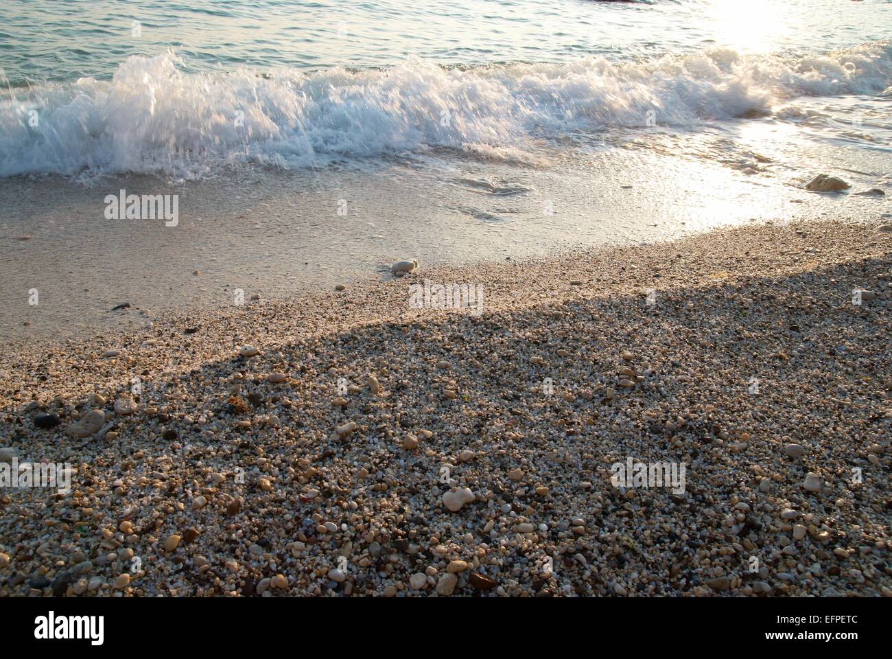 Tropical sand beach with sea waves and stones Stock Photo - Alamy