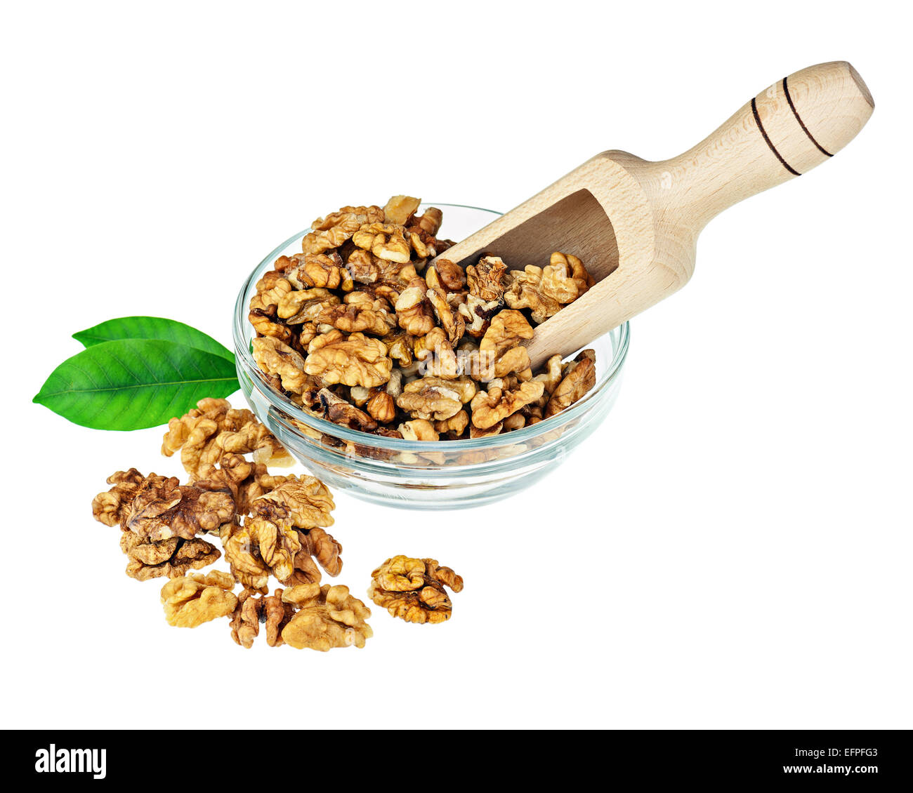 Handful of walnuts in glass bowl, scoop and green leaves isolated on ...