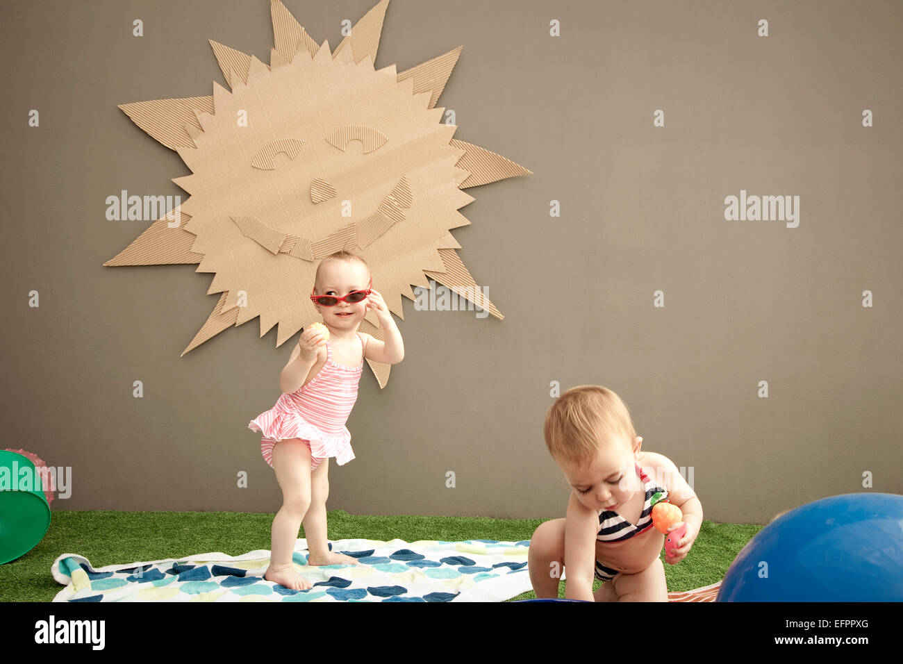 Baby girls with sunshine cutout Stock Photo - Alamy