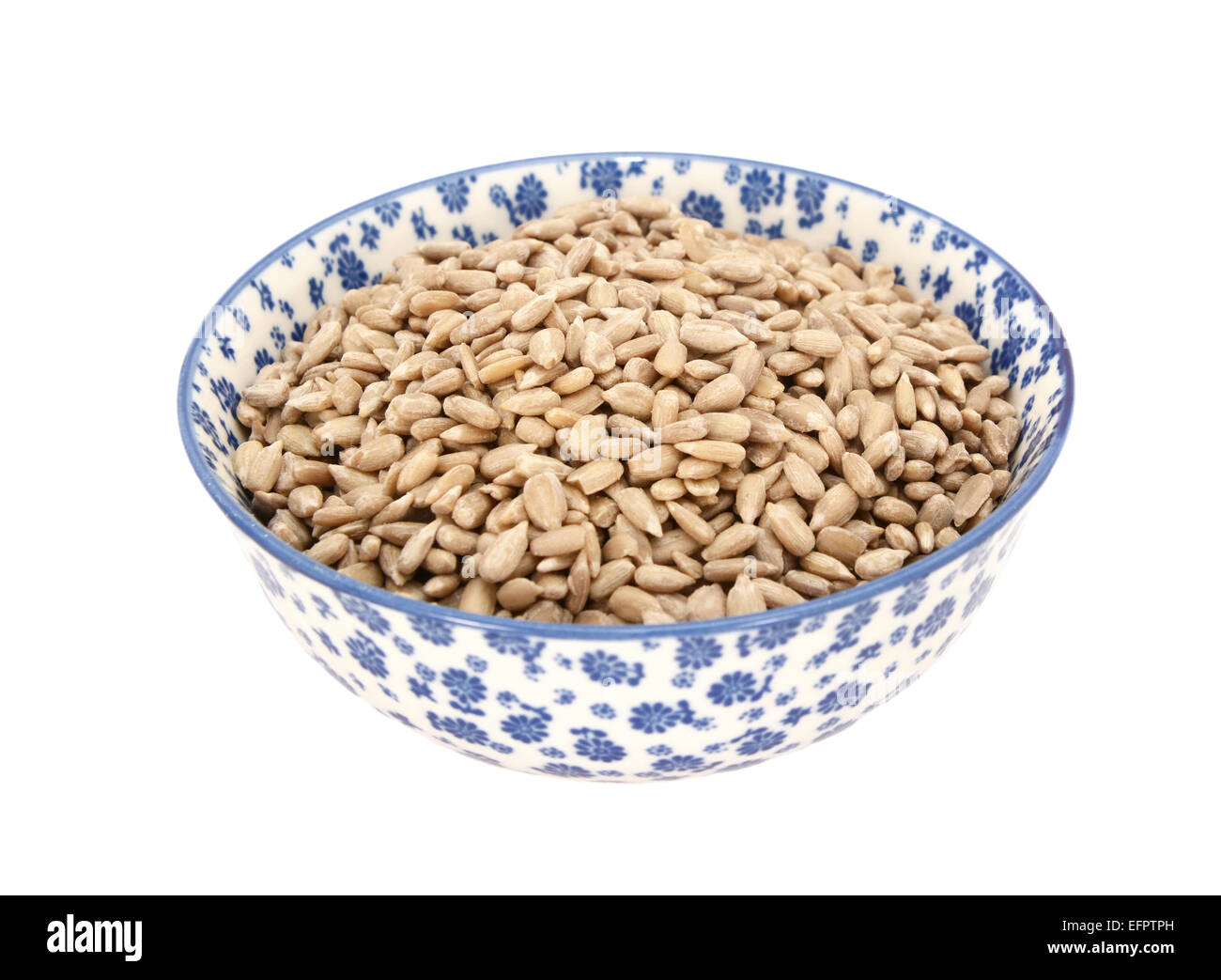 Hulled sunflower seed hearts in a blue and white porcelain bowl with a ...