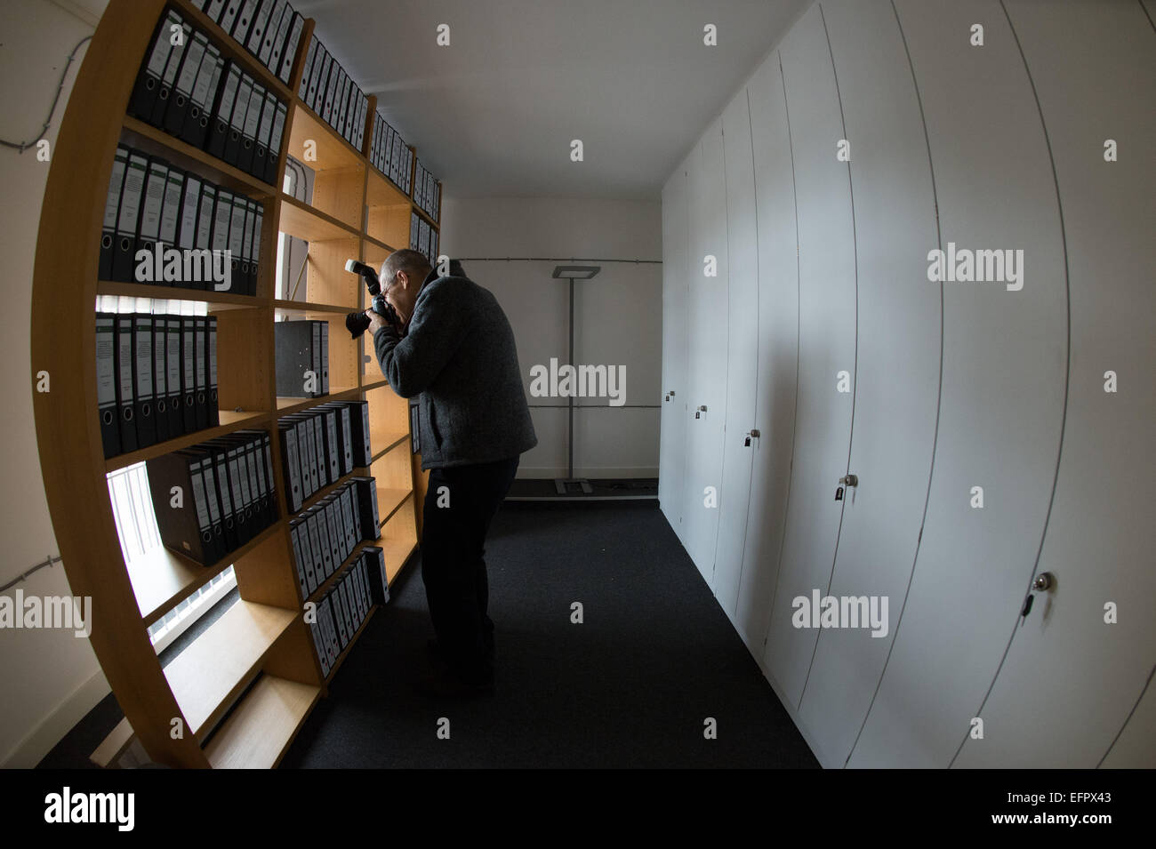 A journalist takes pictures of file folders in a secure room for the ...