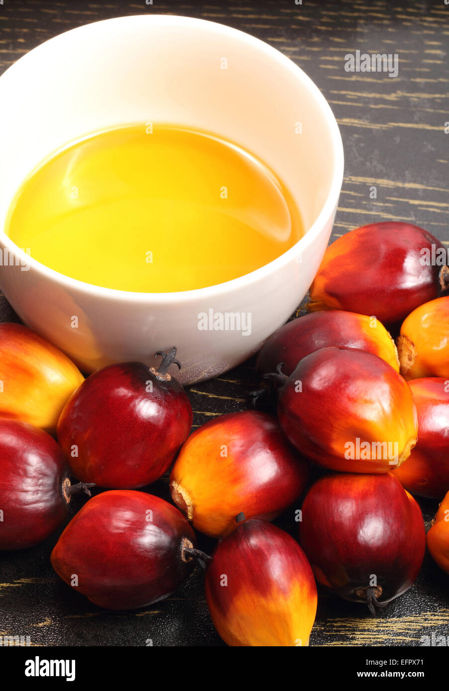 Oil palm fruits and bowl of cooking oil on black background Stock Photo ...