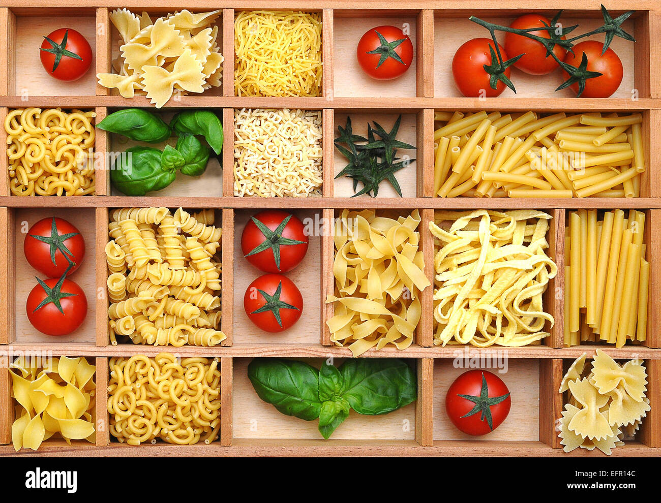 Type case with pasta, basil and tomatoes Stock Photo - Alamy