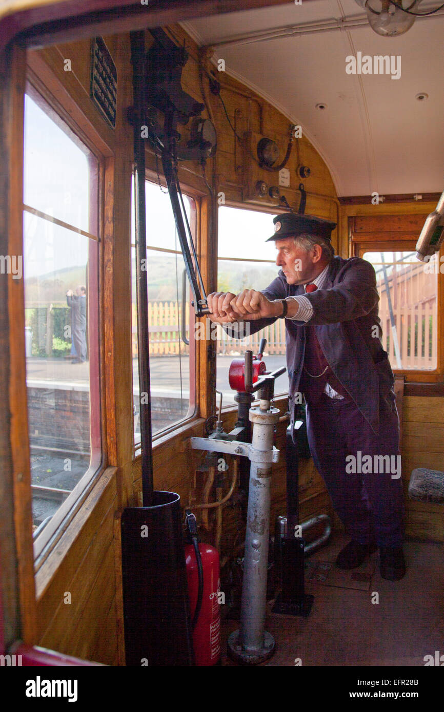 The driver of ex-GWR 'Autocoach' starts his train at Williton station ...