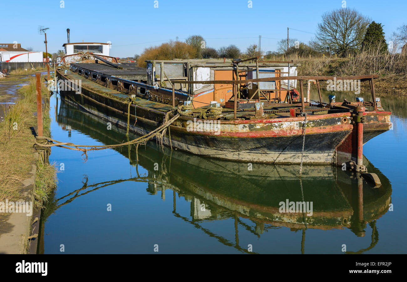 A derelict river boat lays moored along the river Hull surrounded by ...