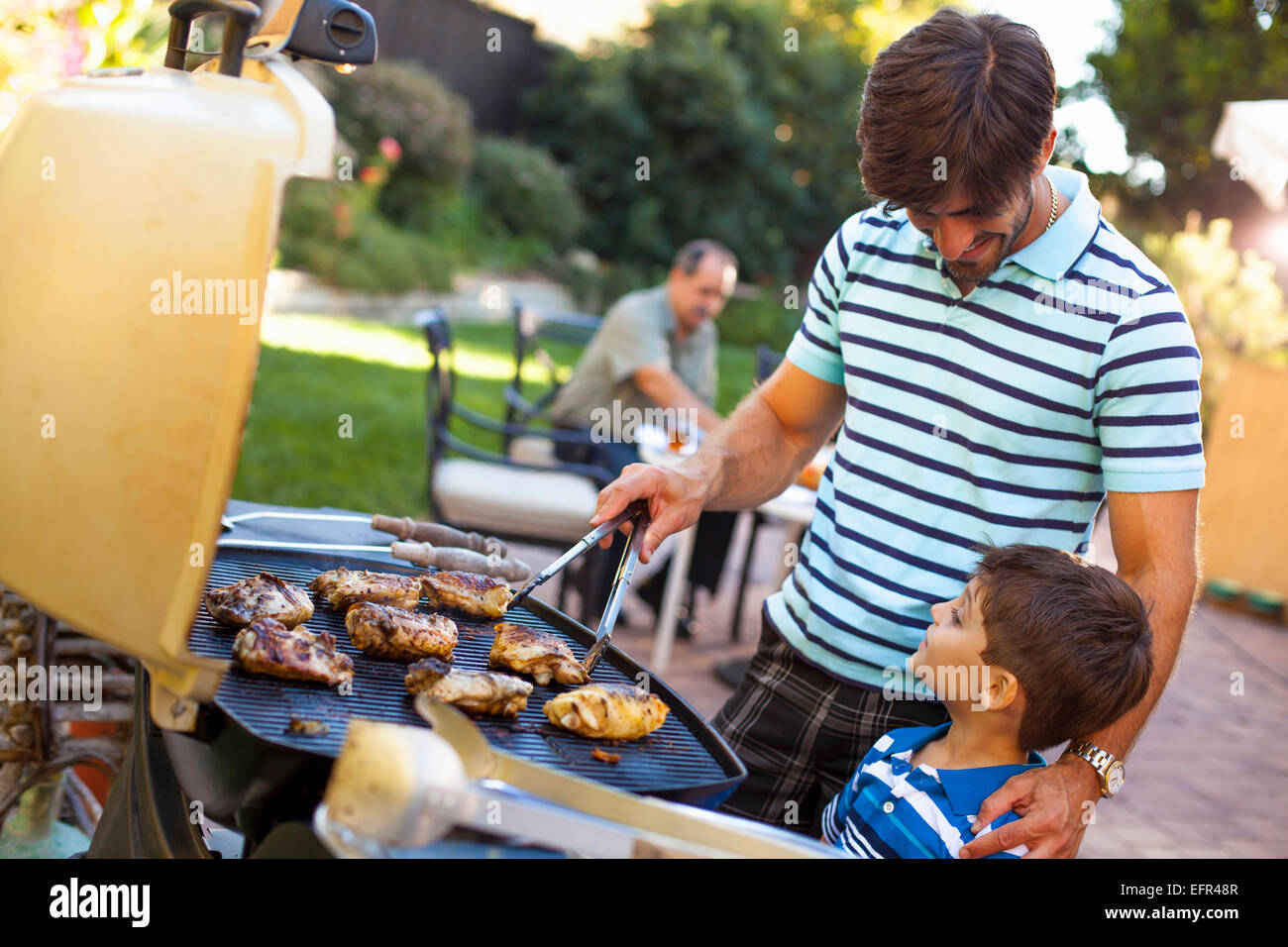Father and son at barbecue grill in garden Stock Photo - Alamy