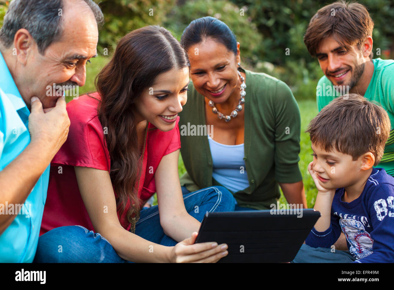Three generation family using digital tablet in garden Stock Photo - Alamy