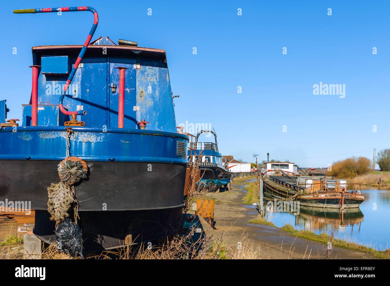 A derelict river boat lays moored along the river Hull surrounded by ...