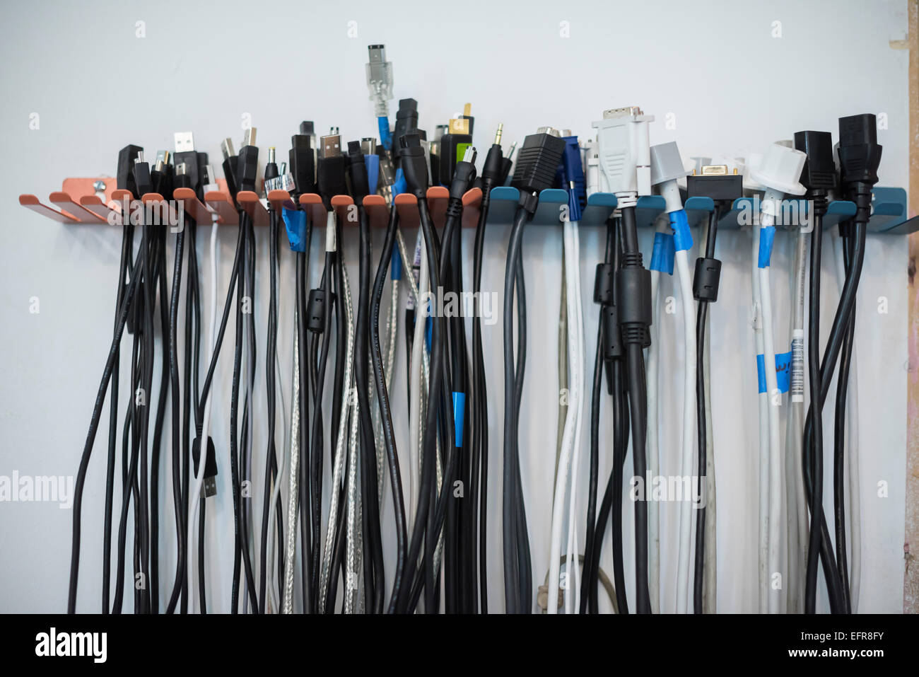 Cables arranged in rows on a wall rack Stock Photo - Alamy