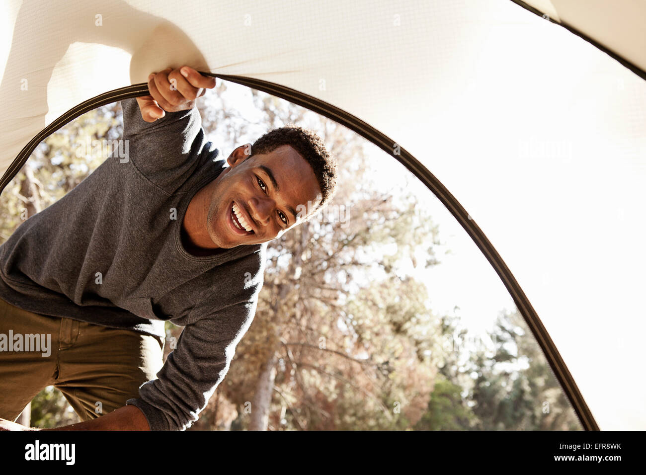 Portrait of young man leaning forward in tent entrance Stock Photo - Alamy