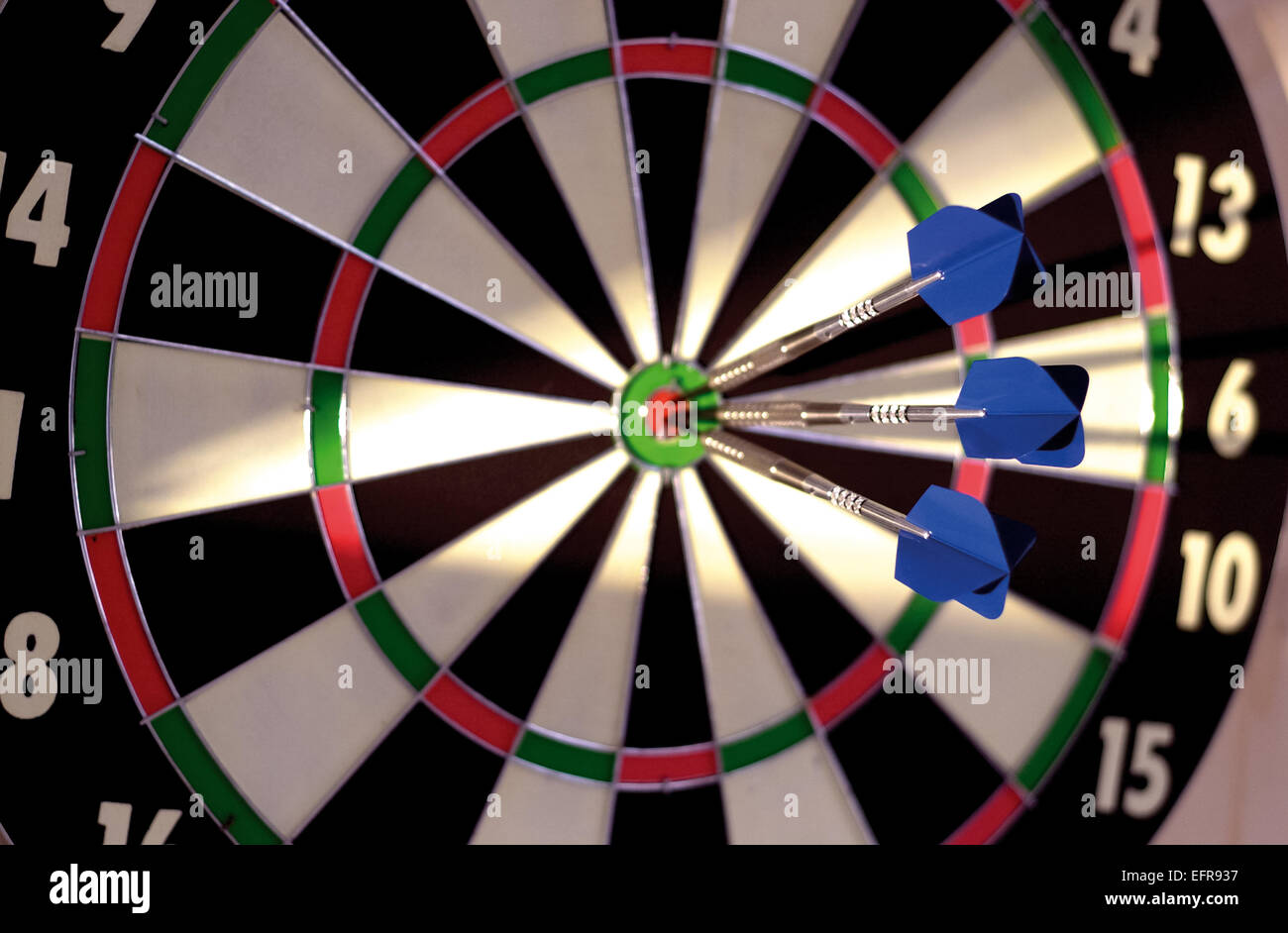 Dartboard with darts in centre Stock Photo - Alamy