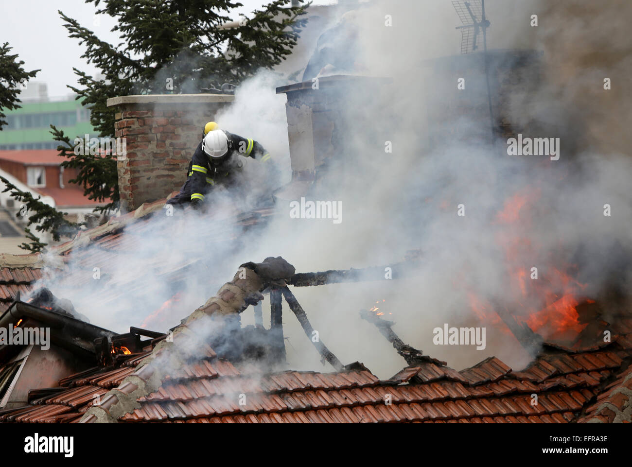 Firefighters on a burning house roof Stock Photo - Alamy