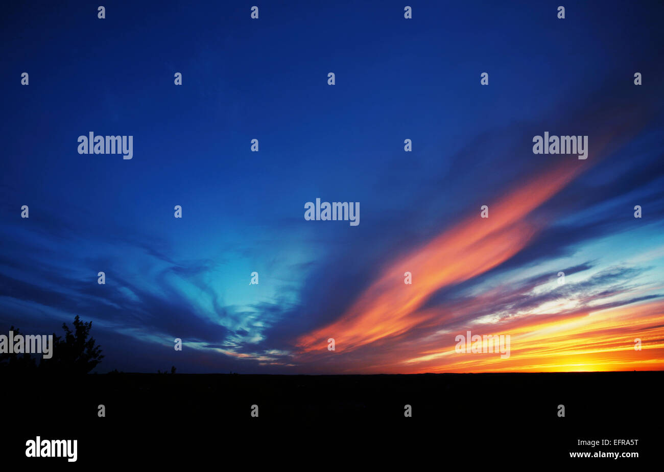 Shafts of sunlight from the setting sun illuminating the clouds in a ...