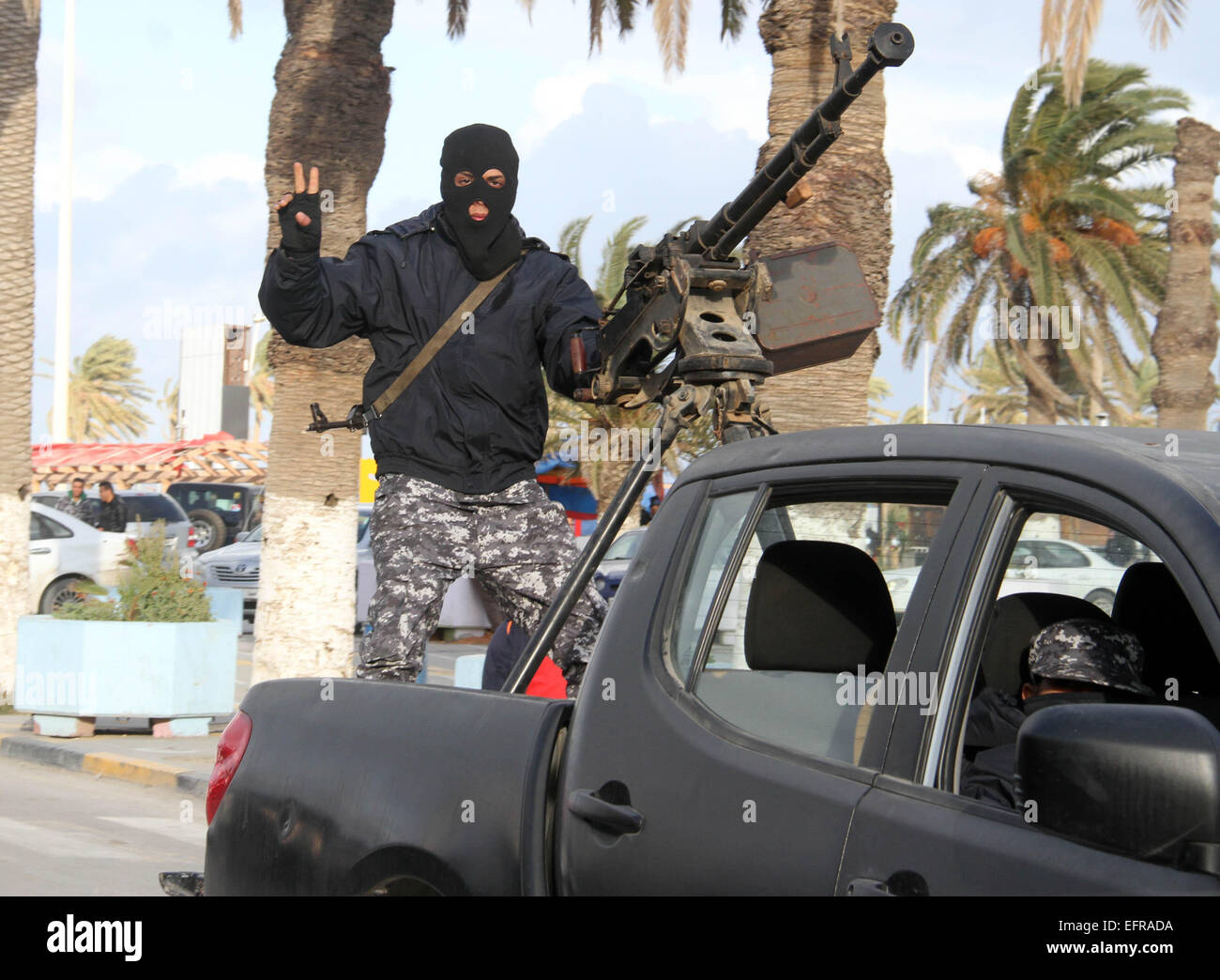 Tripoli. 9th Feb, 2015. A masked soldier poses for photo on an armored ...