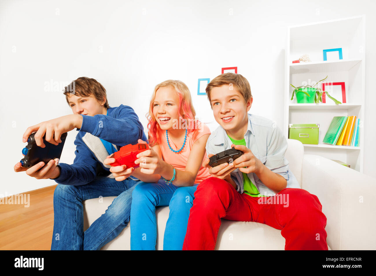 Girl and boys with joysticks playing game console Stock Photo - Alamy