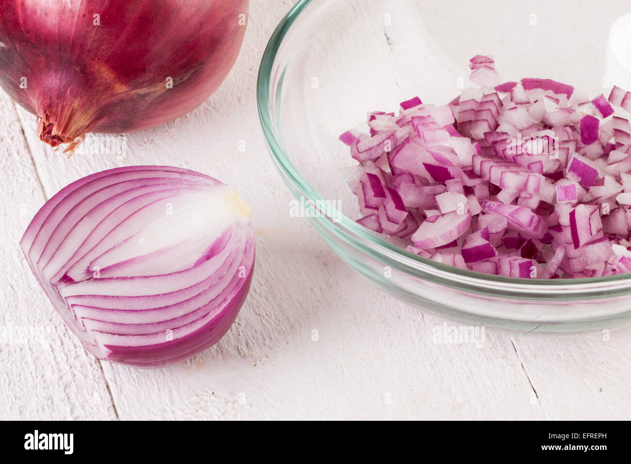 Heap of fresh finely diced red onion with a peeled half showing a cross ...