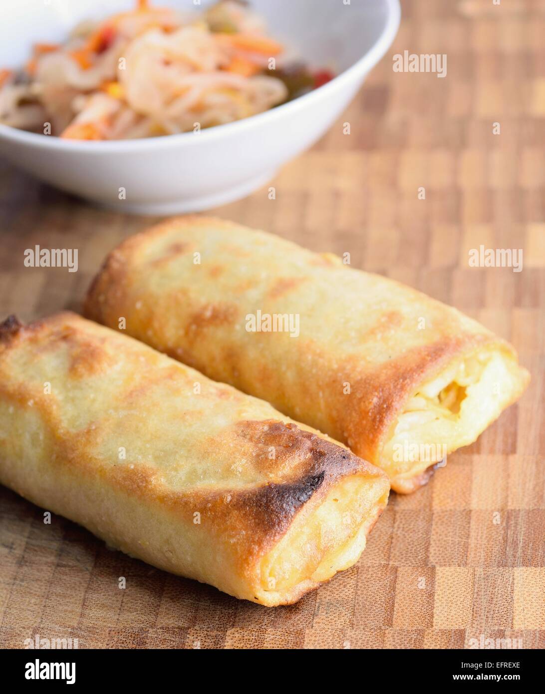 Chinese spring rolls on a wooden plate with vegetable salad Stock Photo ...
