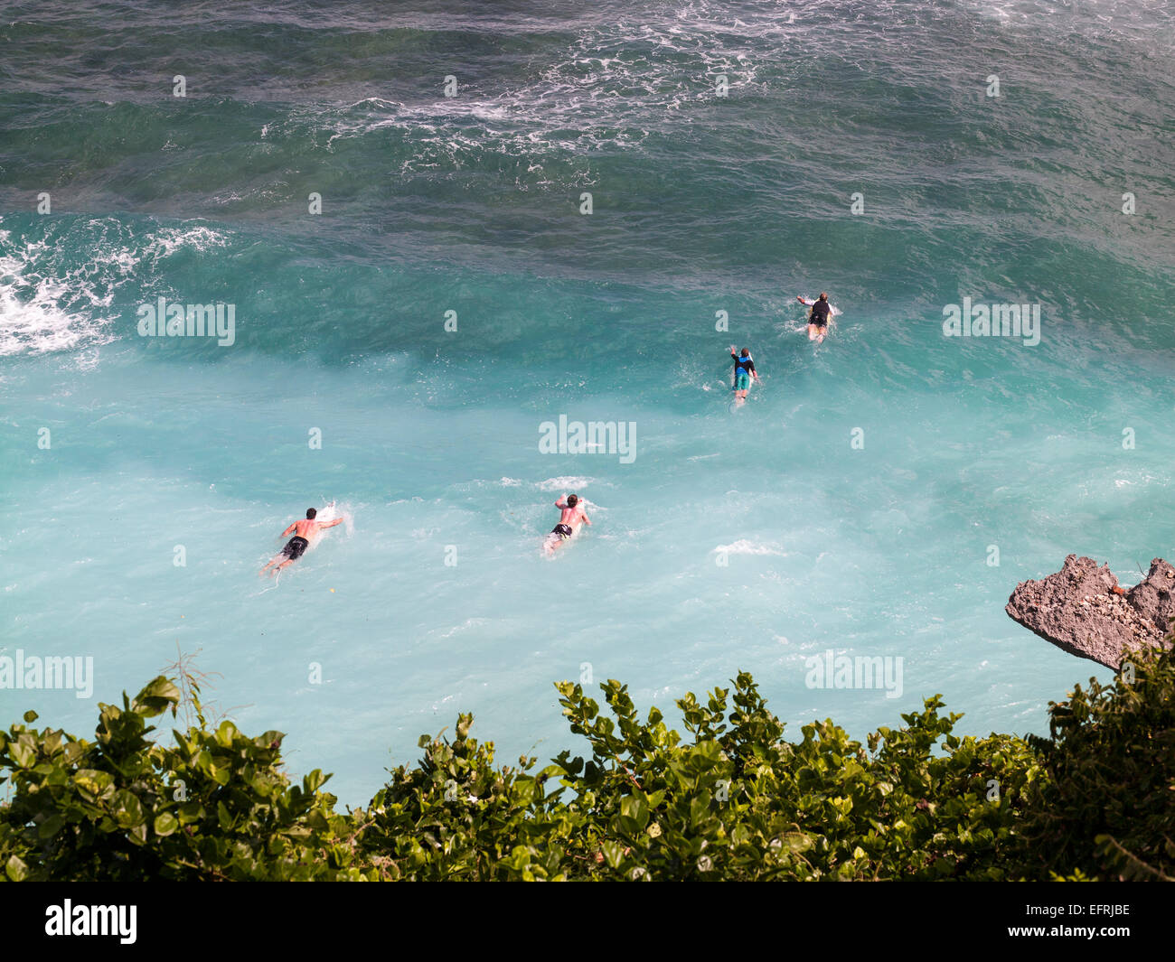 Surfers swimming in Bali, Indonesia Stock Photo - Alamy
