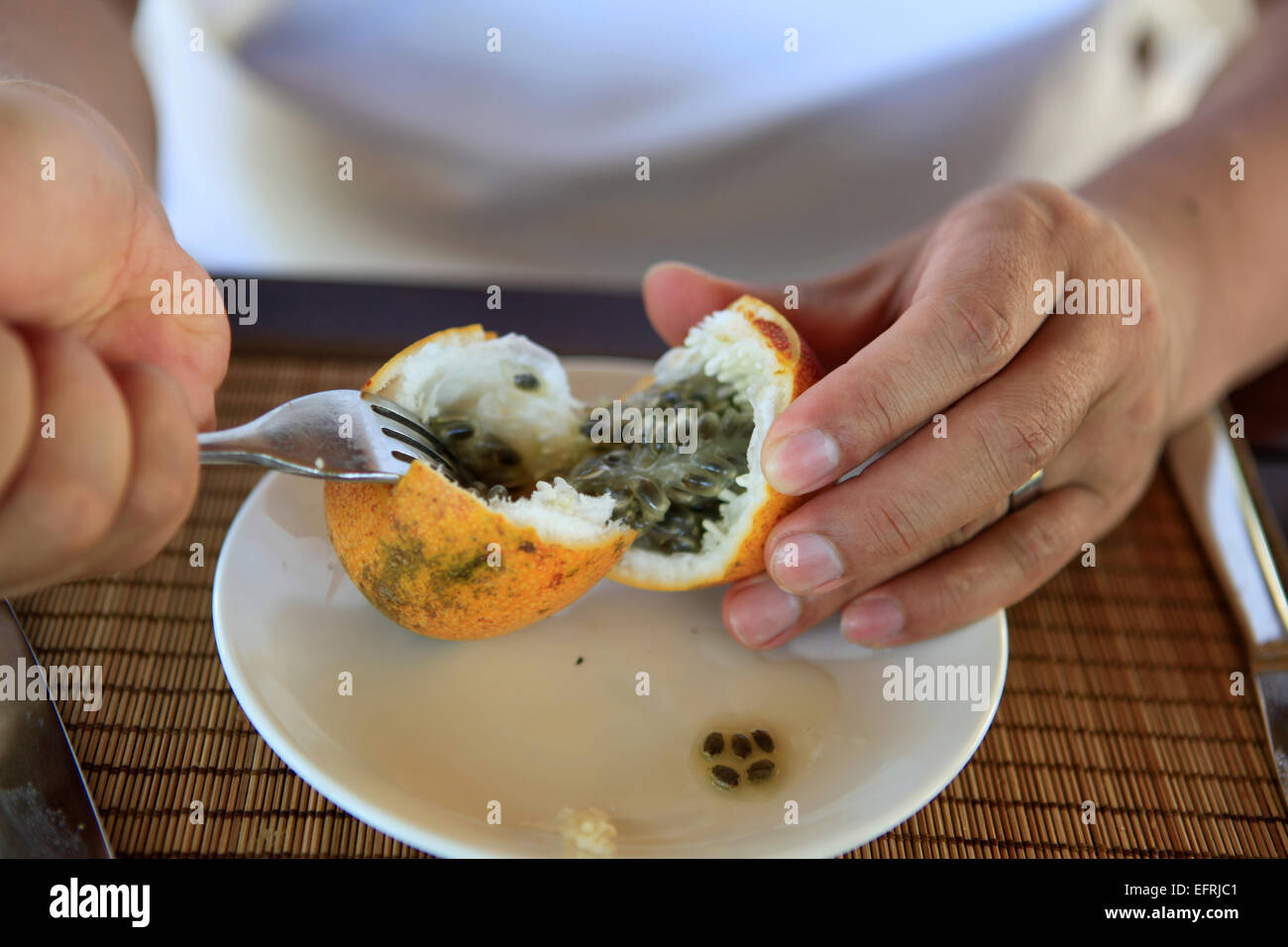 Hand of a man eating passion fruits Stock Photo - Alamy