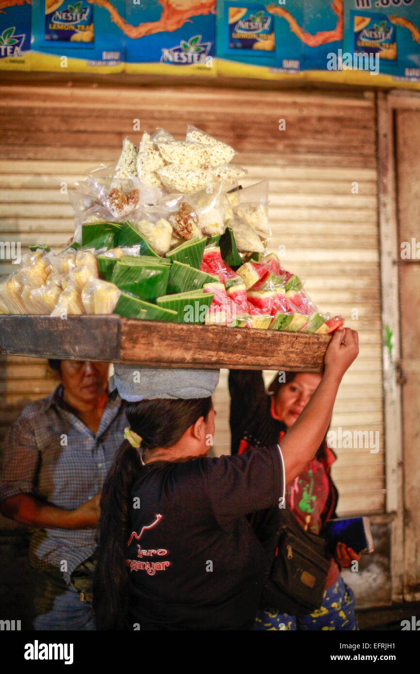 A woman carrying food on her head in Bali, Indonesia Stock Photo - Alamy
