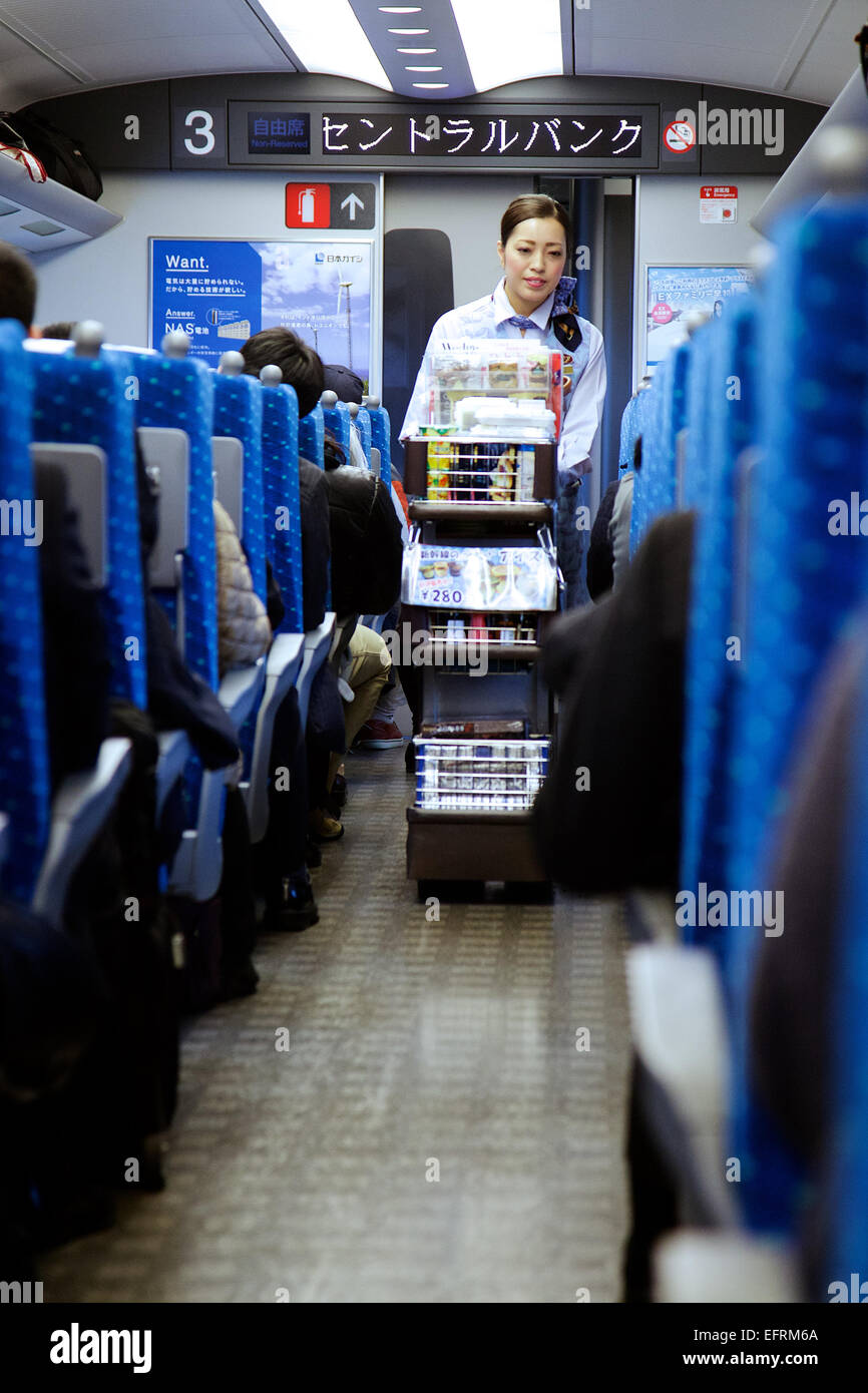 Osaka, JP - January 21, 2015 : A female snack vender serves passengers ...