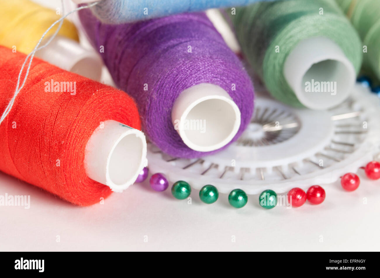 Sewing strings and needles on a light background Stock Photo - Alamy
