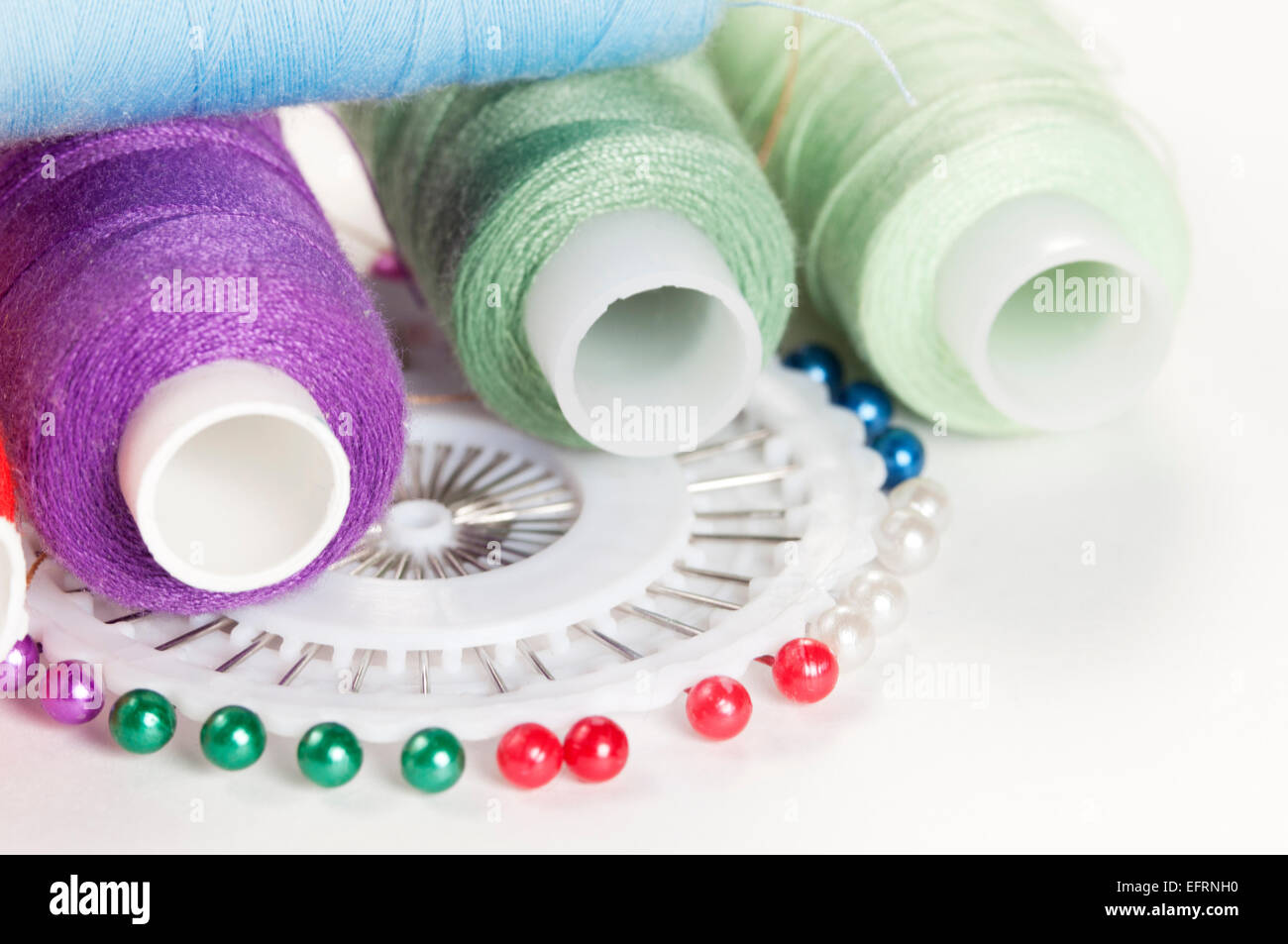 Sewing strings and needles on a light background Stock Photo - Alamy