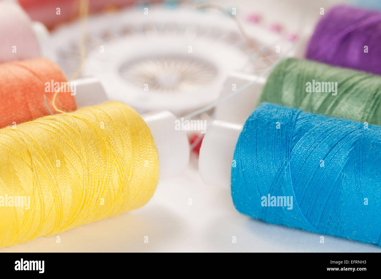 Sewing strings and needles on a light background Stock Photo - Alamy