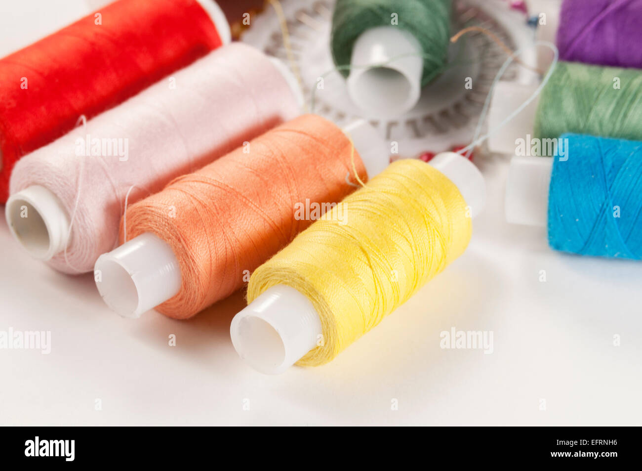 Sewing strings and needles on a light background Stock Photo - Alamy