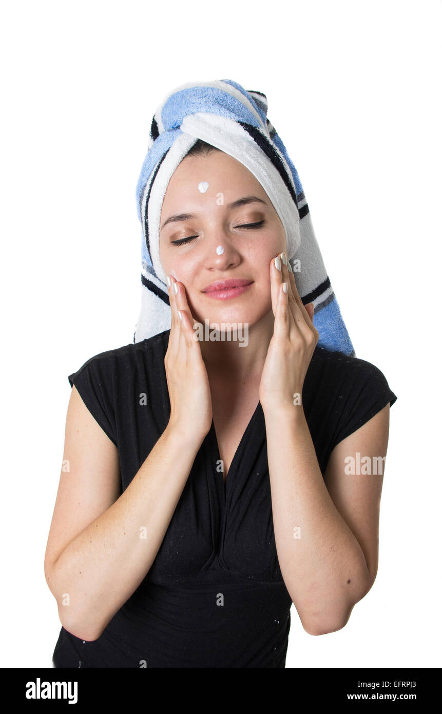 beautiful young woman applying cleaning cream moisturizer to her face ...