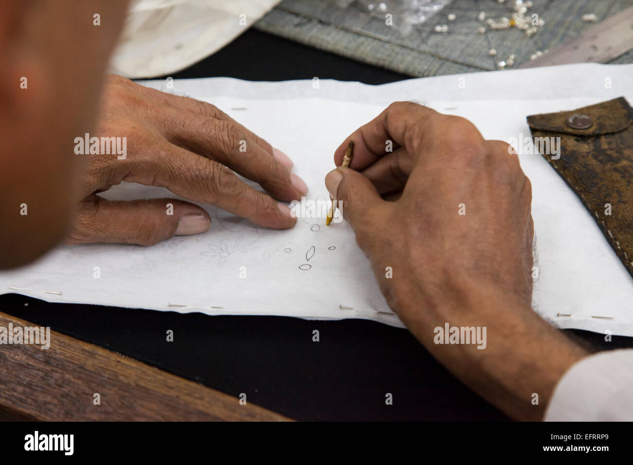 Worker drawing stencil motif on cloth Stock Photo - Alamy