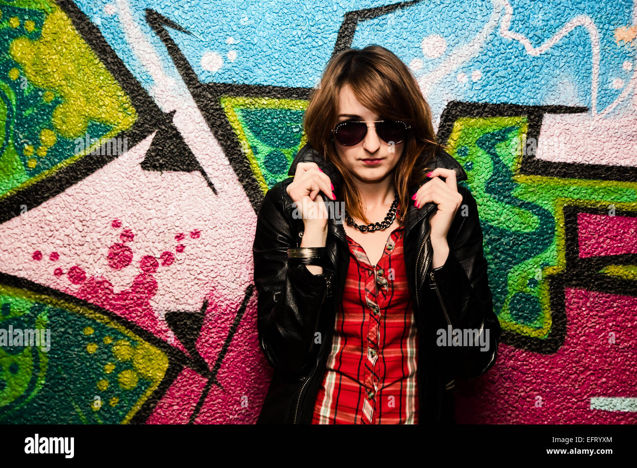 Stylish fashionable girl posing against colorful graffiti wall. Fashion ...