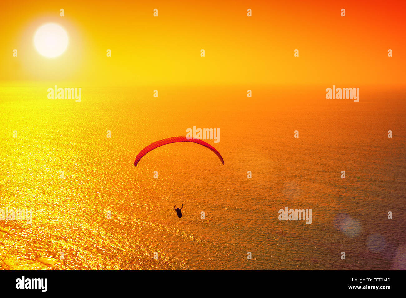 Silhouette of paraglider soaring over sea at sunset Stock Photo - Alamy