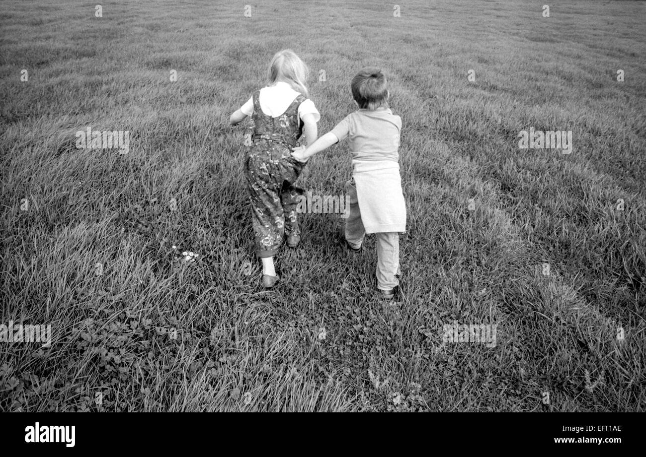 Two children run free in a field Stock Photo - Alamy