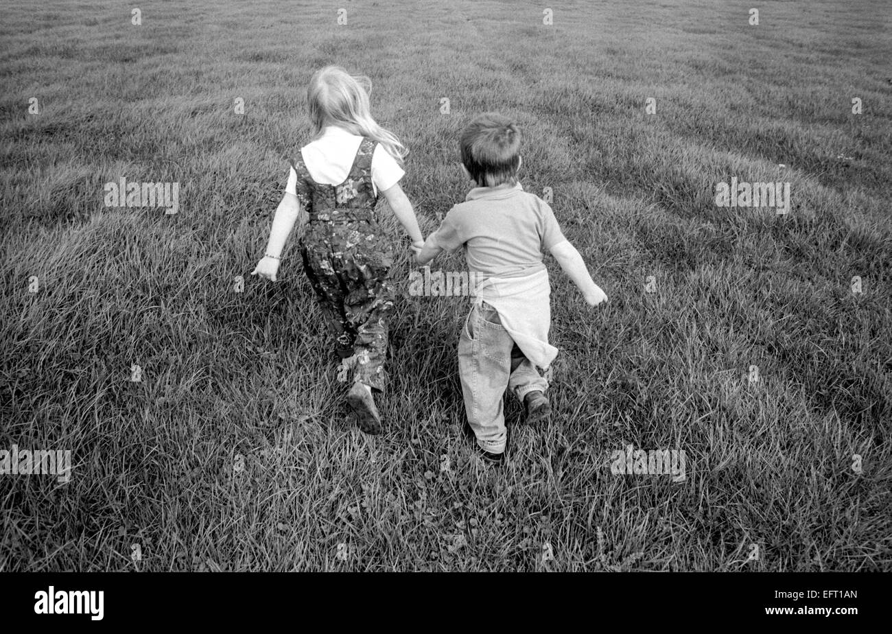 Two children run free in a field Stock Photo - Alamy