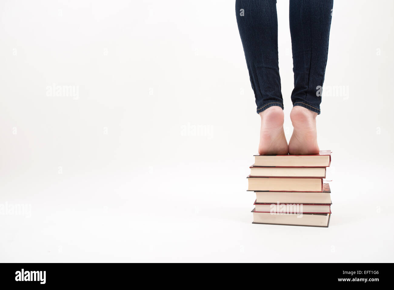Woman standing on pile of books Stock Photo - Alamy